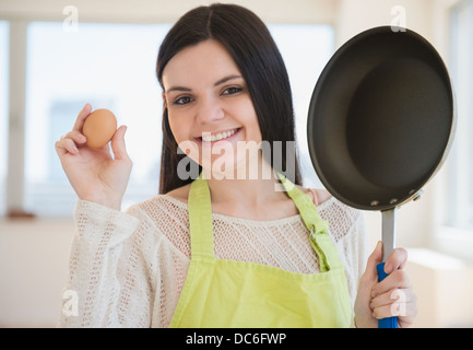 Young woman holding frying pan, portrait Stock Photo - Alamy