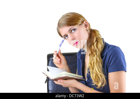 Lovely young woman thinking while writing on notepad Stock Photo - Alamy