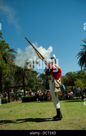 Adult man in period military costume, firing a muzzle-loading musket ...