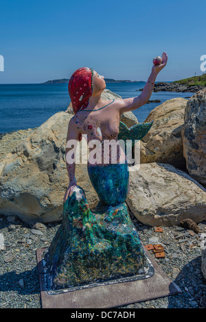 A mermaid sculpture, with the mermaid gesturing with arm extended ...