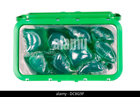 Laundry capsules. Laundry gel in capsules and white towel on grey ...