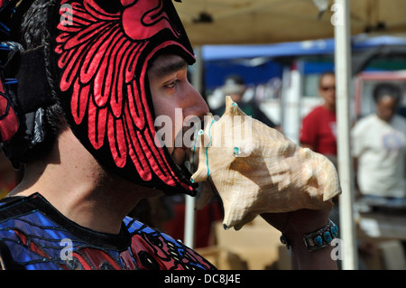 Man dressed as Aztec warrior blowing a conch shell Stock Photo - Alamy