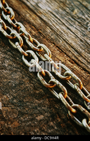 Rusty chain links on wood close up vertical Stock Photo - Alamy