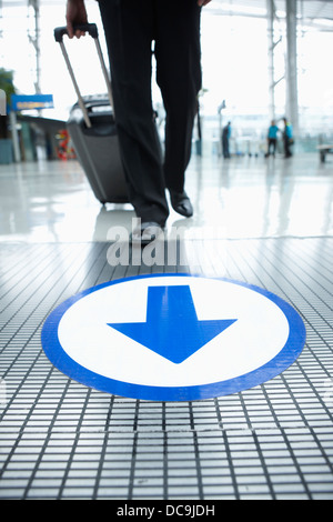 a businesswoman stepping to an arrow sign in the airport Stock Photo ...