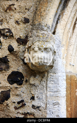 Carved stone head at the base of hooded moulding over the chancel door ...