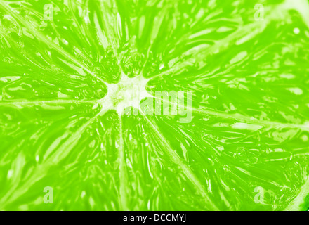 Vibrant green lime and juicy slice on weathered wood. Warm lighting ...