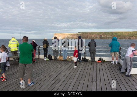 Men fishing from the end of Saltburn pier on the north east coast ...
