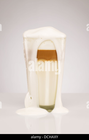 White cup with foaming cappuccino coffee and spoon on wood table aerial ...