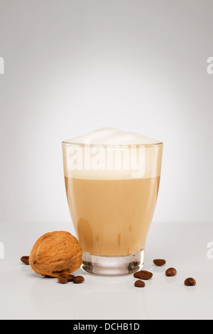 Macchiato coffee in the small glass cup and piece of nut cake Stock ...
