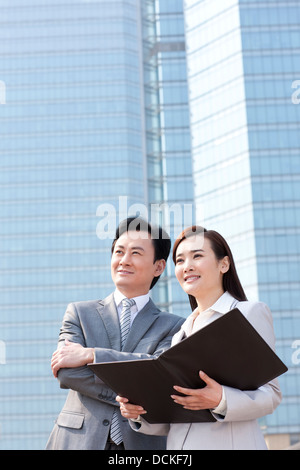 Confident Chinese business partners arms crossed in logistic warehouse ...