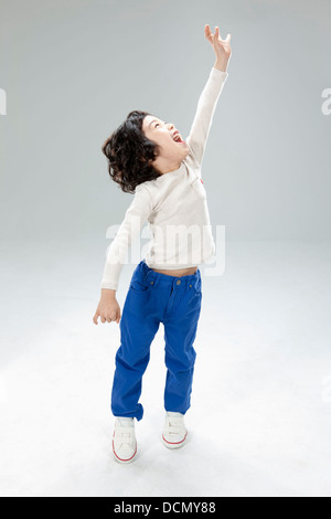 a boy jumping to reach something Stock Photo - Alamy