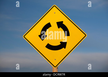 A Yellow Traffic Sign With Three Arrows In A Circle Against A Blue Sky ...