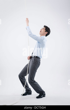 a business man pulling a wire Stock Photo - Alamy