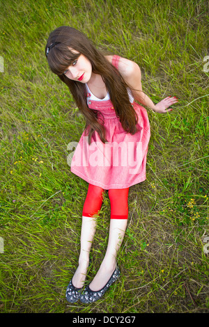 Pretty girl in red sarafan lies on the green grass Stock Photo - Alamy