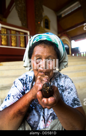 A leper woman lighting up her pipe Stock Photo - Alamy