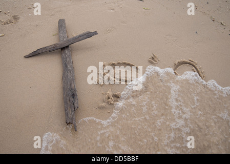 The word "sin" written in the sand, being washed away by a wave Stock ...