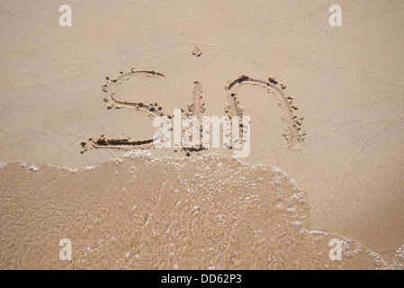 The word "sin" written in the sand, being washed away by a wave Stock ...