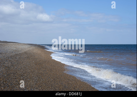 Shingle beach and sea defenses with waves lapping the shore at Cley ...