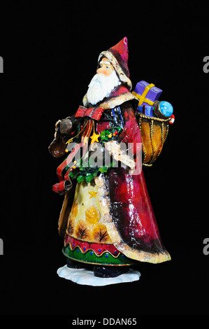Tin Father Christmas on a black background Stock Photo - Alamy
