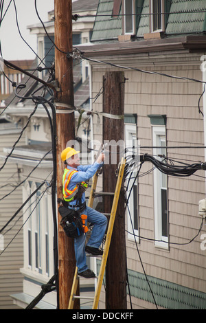 Cable lineman standing on a ladder to repair transmission line Stock ...
