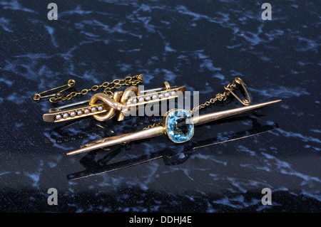Two antique gold scarf pins against a black background Stock Photo - Alamy