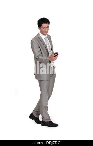 Businessman sending message as walking to work, busy lifestyle ...