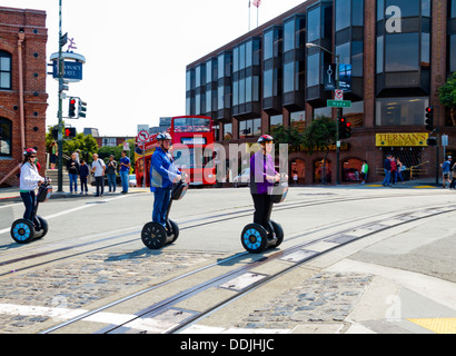 Happy man and woman riding segway and looking for way Stock Photo - Alamy
