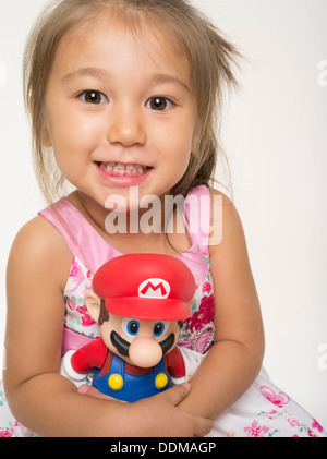 Young girl playing with her pink Nintendo. Game Over is displayed on ...