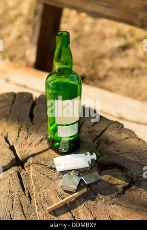 Close-up of a brown cigarette and a syringe filled with a dose of ...