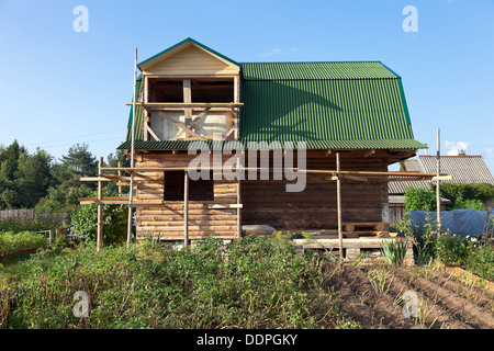 The frame of an unfinished wooden house on a mountain slope, amidst ...