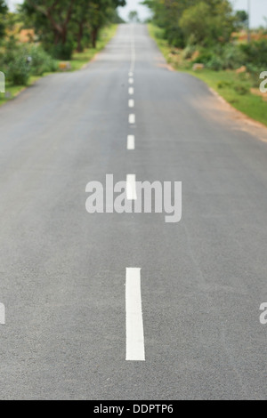 A rural country road going straight into the horizon in a black and ...