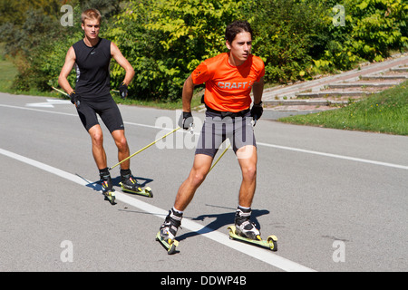 Two young man practicing roller skiing in the park (as a summer ...