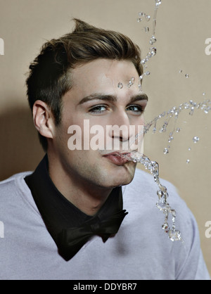 Young man spitting out water Stock Photo - Alamy
