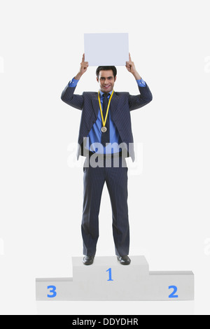 Businessman with medal holding a placard Stock Photo - Alamy