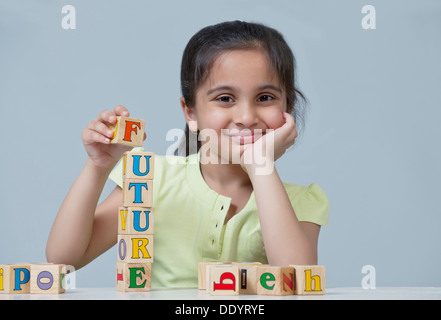 Little girl stacking blocks isolated over blue background Stock Photo ...