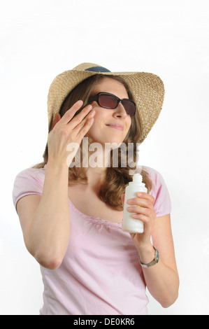 A closeup shot of sunglasses and hat on a table with a beach in the ...