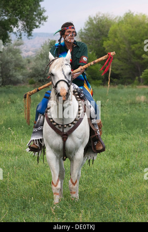Warrior in Comanche clothing riding white horse Stock Photo - Alamy