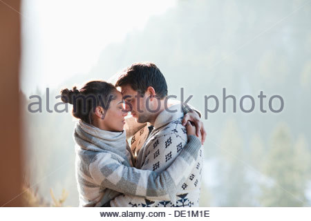 Back view of young embracing couple (man and woman) hug and look into ...