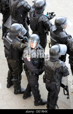 Riot police in full combat gear on standby in the town plaza during ...