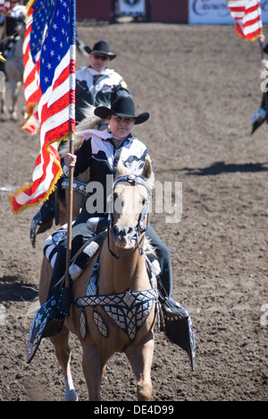 Rodeo cowgirl riding horse carrying American flag during the 4th Annual ...