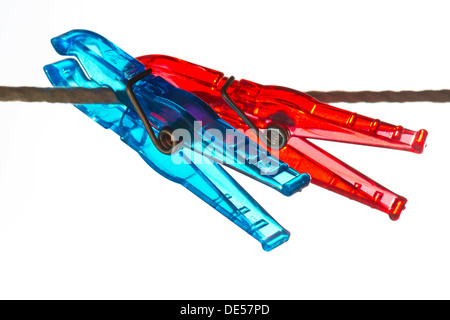 Red blue and white clothes pegs clipped on a washing line with a blue ...