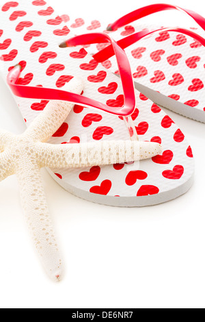 Star sea shell with flip flops on a white background Stock Photo - Alamy