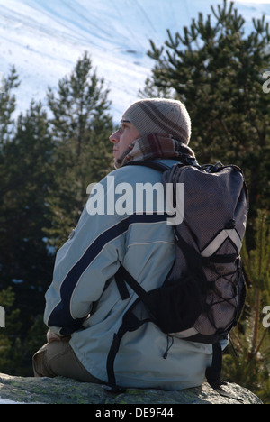 Solitary young man resting on the edge of an infinity pool looking out ...