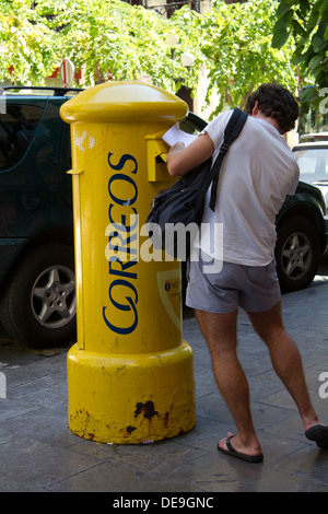 Man posting a letter in postbox outside post office, Cumbria, England ...