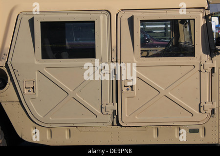 Side window of an armored military truck with a rearview mirror and a ...