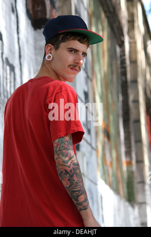 A young Rapper walking down a urban street Stock Photo - Alamy