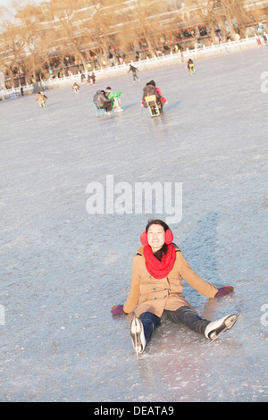 Young Woman Falling While Ice Skating Stock Photo - Alamy