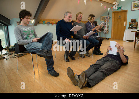 Actors in rehearsal, holding their scripts, reading lines of dialogue ...