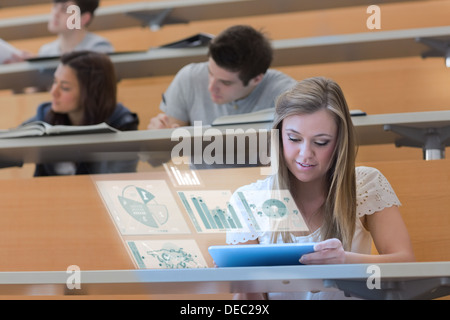 Pretty female university student working on laptop in cafe, writing ...