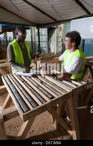 Technical logging of core samples in core shed by geologist, surface ...